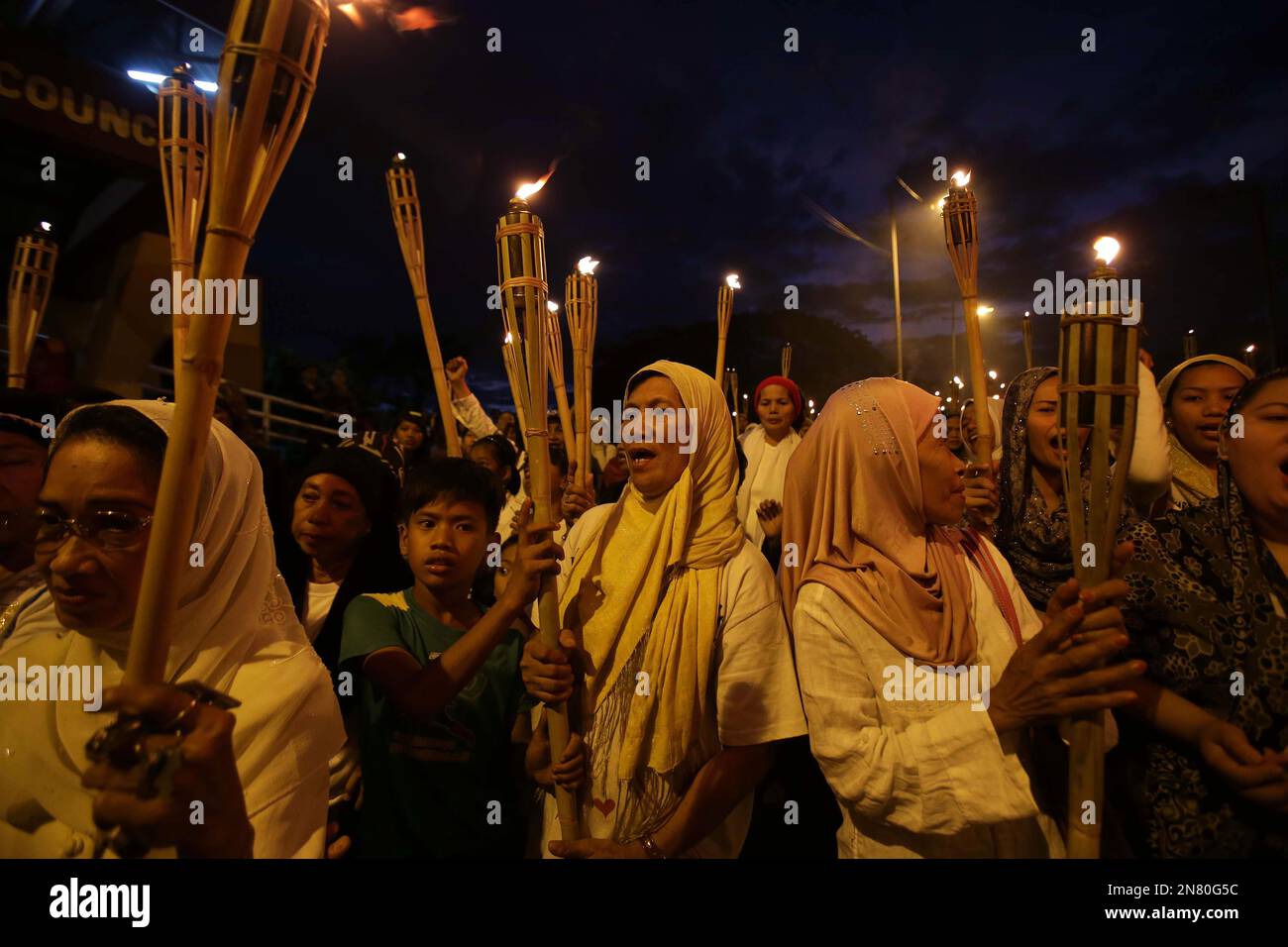 Filipino Muslim women shout slogans as they carry torches during a ...