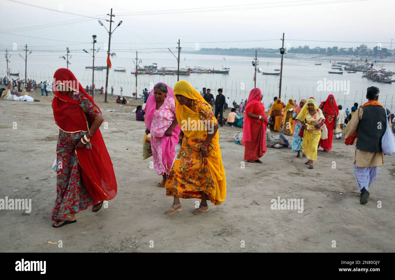 In this Tuesday, March 5, 2013 photo, Hindu devotees walk back after ...
