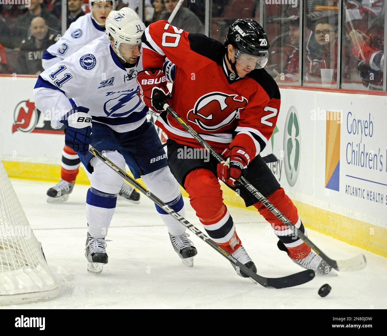 New Jersey Devils' Ryan Carter, right, handles the puck as he is ...