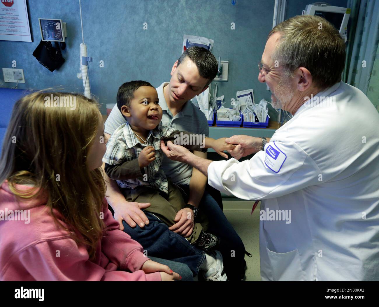 Joel De la Rosa, from the Dominican Republic, sits on the lap of his ...