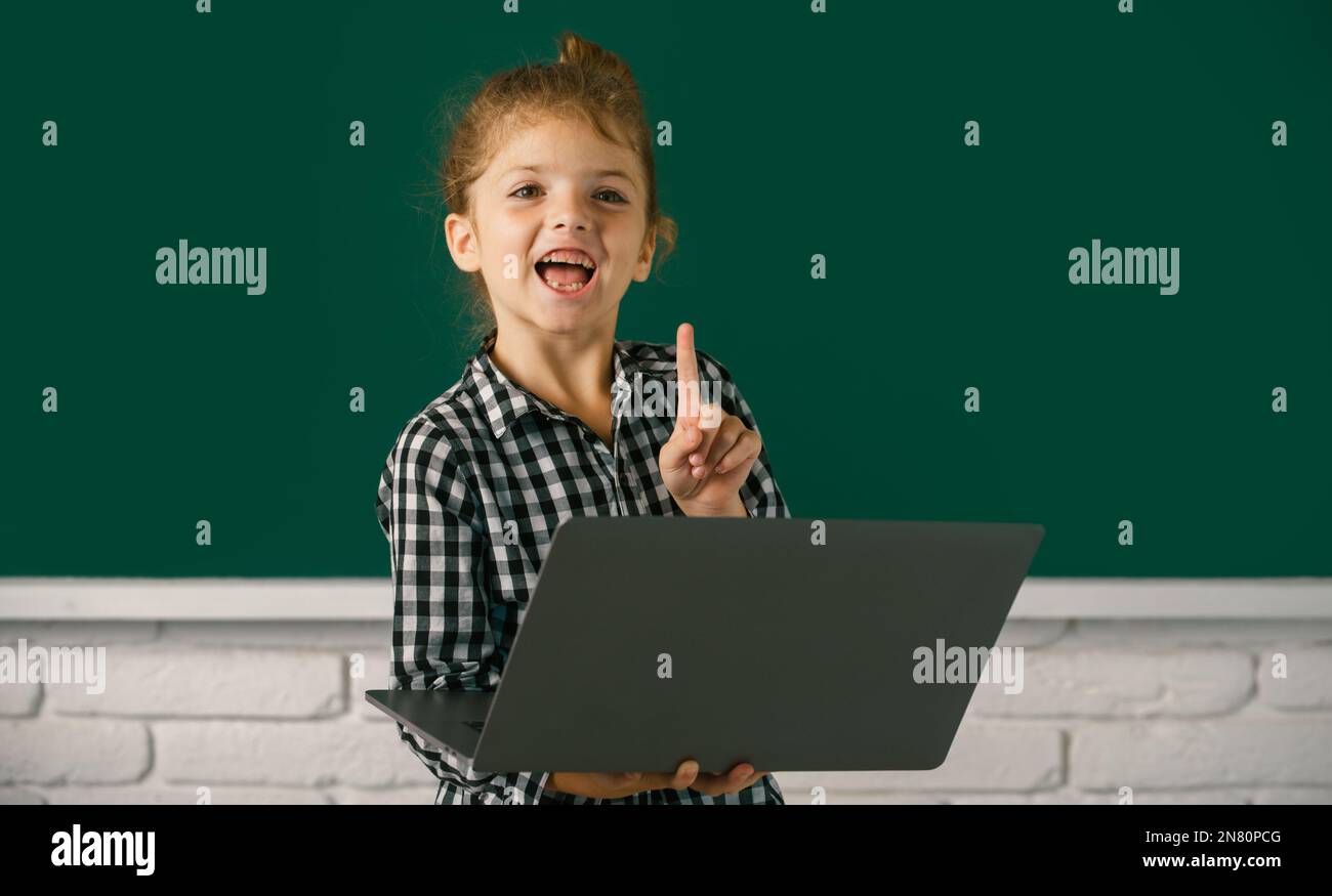 School child girl using digital pc laptop in class. Portrait of funny ...