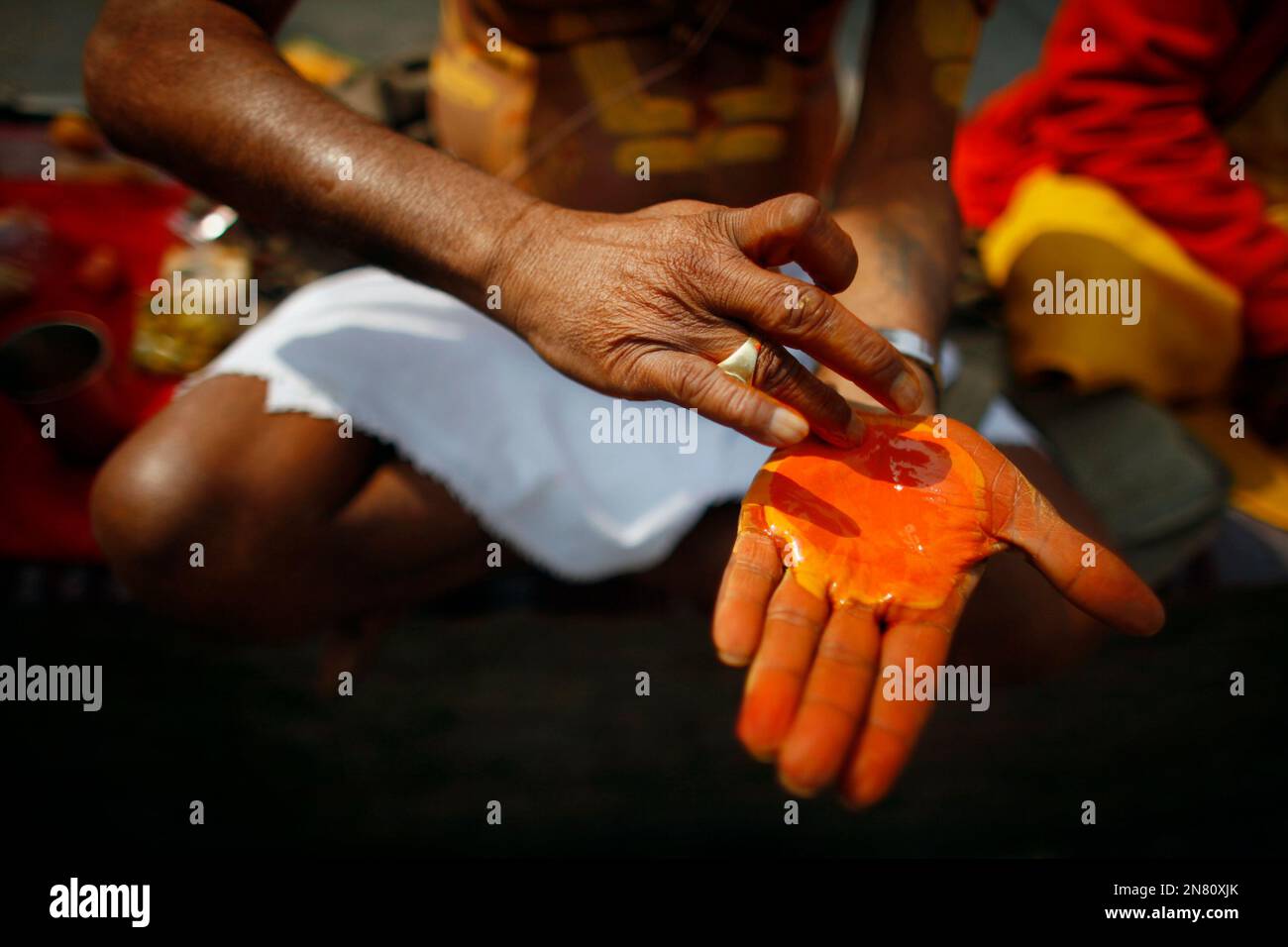 A Hindu holy man mixes vermillion powder at the Pashupatinath Temple in ...