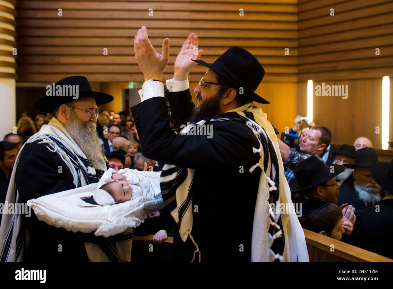 Rabbi Yehuda Teichtal, right, cheers as an other rabbi holds his son ...