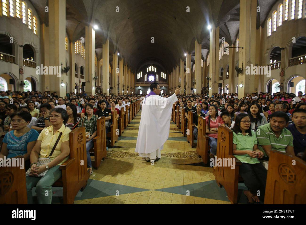 Filipino Catholic Priest Victorino Cueto, center, delivers a sermon ...