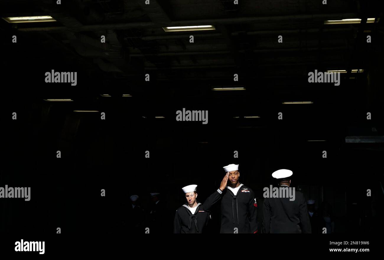 A Navy sailor salutes aboard the USS Freedom before departure Friday ...