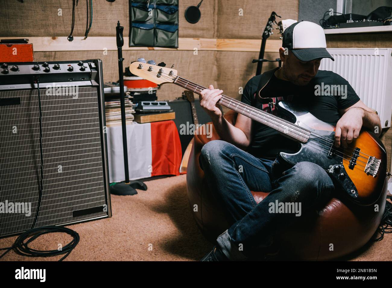 Bass guitarist playing guitar in music studio Stock Photo - Alamy