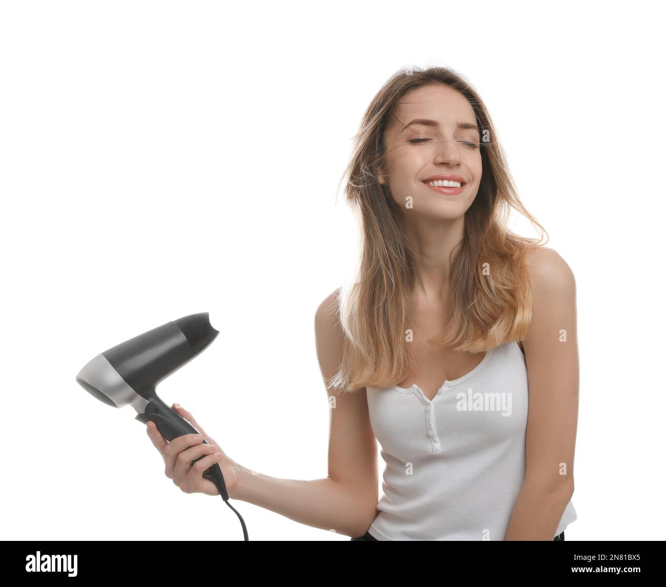Beautiful young woman using hair dryer on white background Stock Photo ...