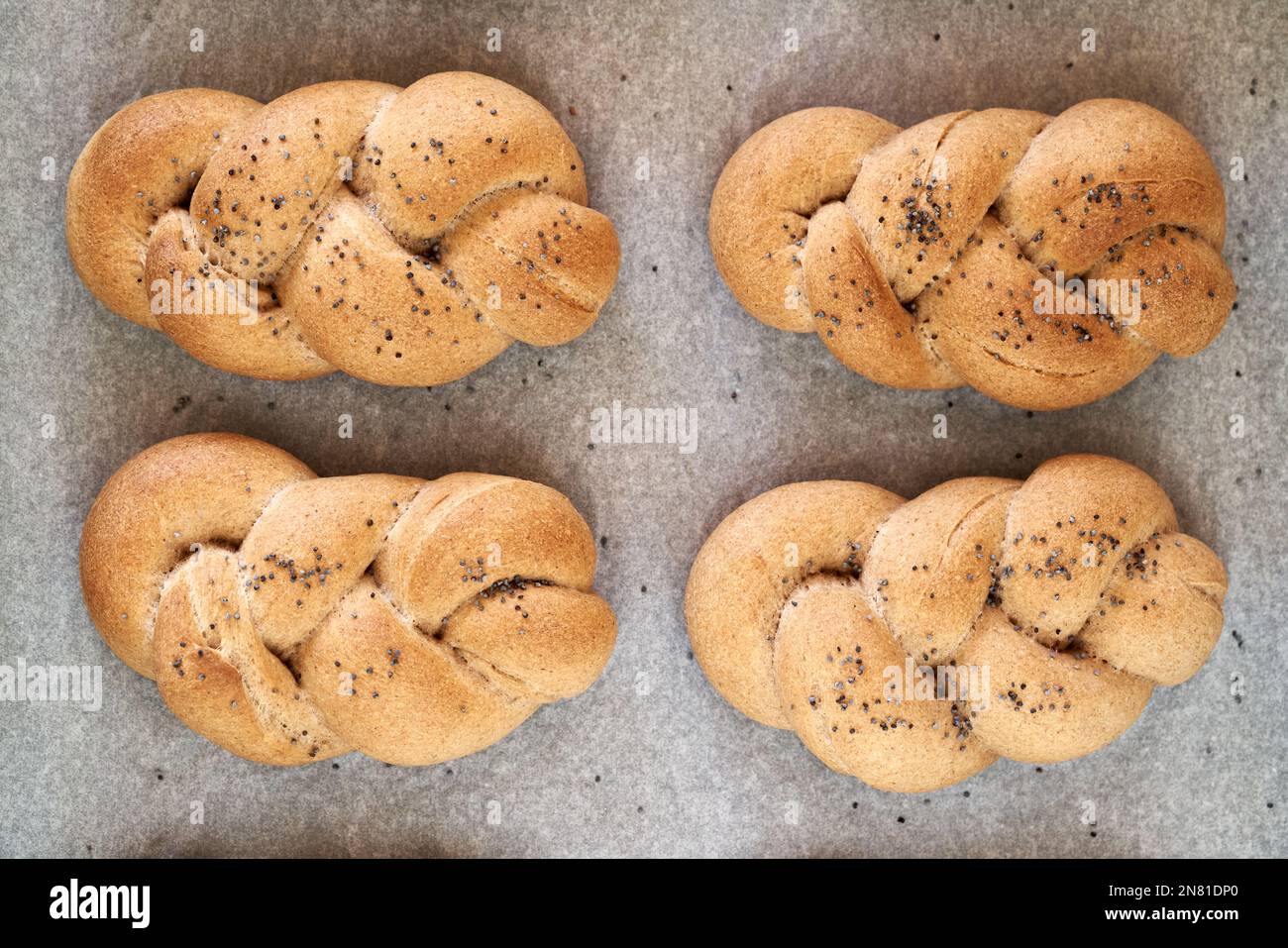 Four rreshly baked braided bread buns made from whole grain spelt flour ...