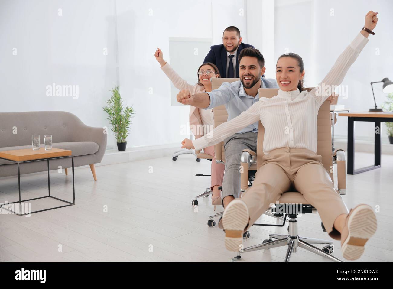 Office employees riding chairs at workplace. Space for text Stock Photo ...