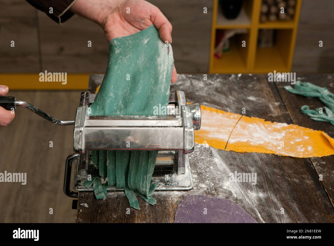 Chief with pasta machine do blue dough for noodles Stock Photo - Alamy