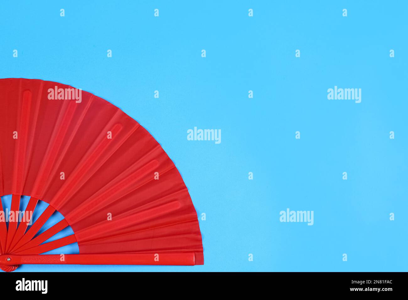 Red hand fan on light blue background, top view. Space for text Stock ...