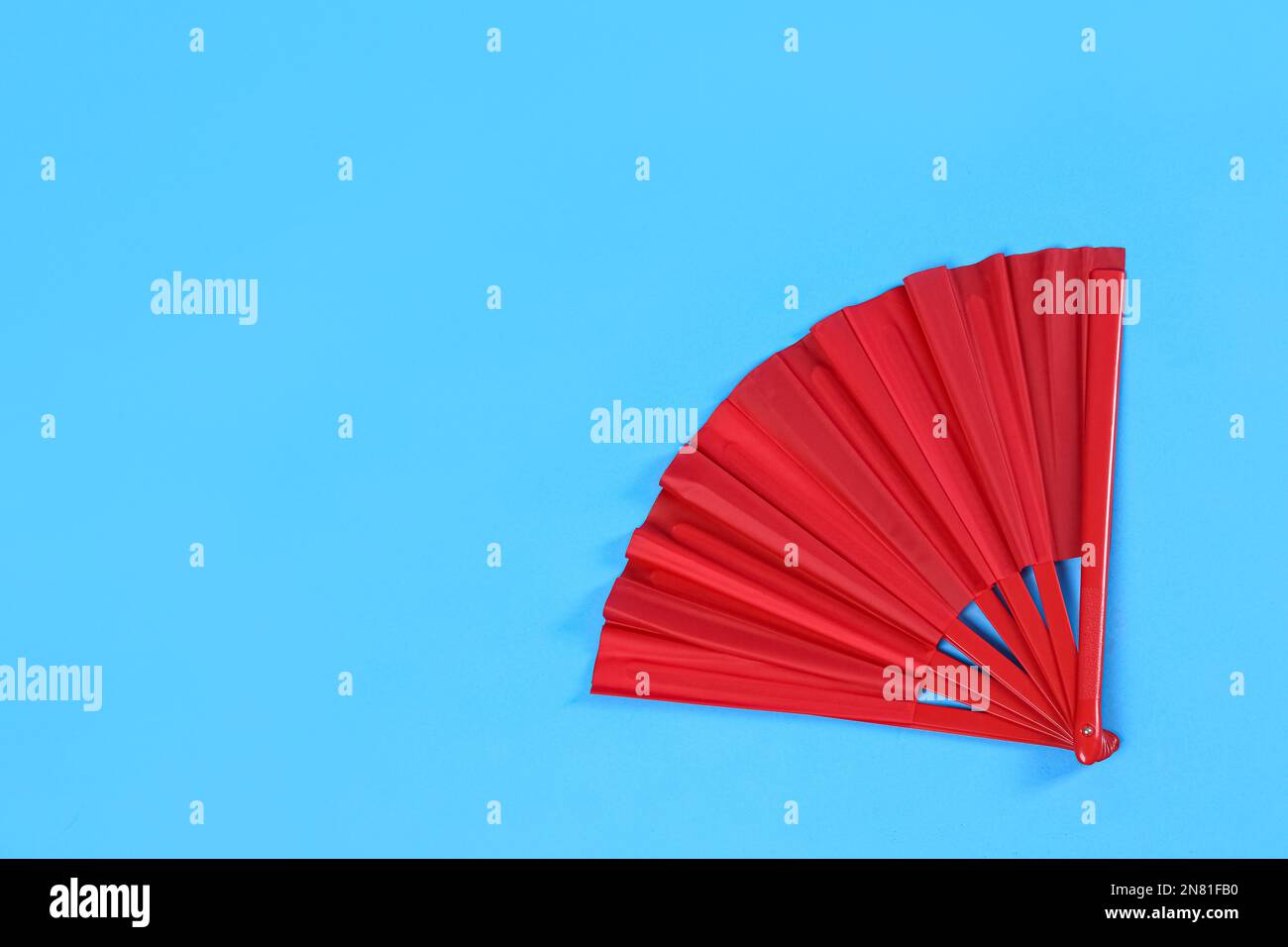 Red hand fan on light blue background, top view. Space for text Stock ...