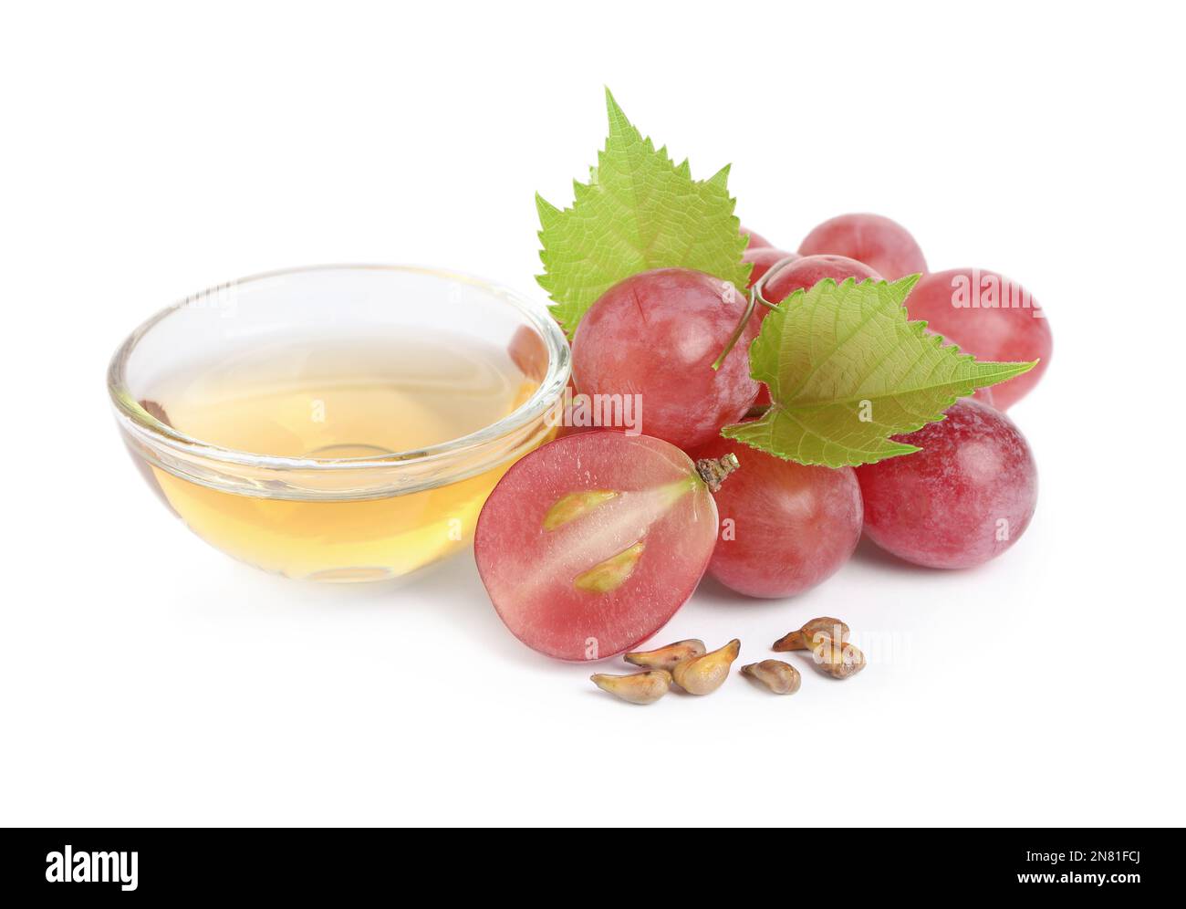 Organic red grapes, seeds and bowl of natural essential oil on white ...