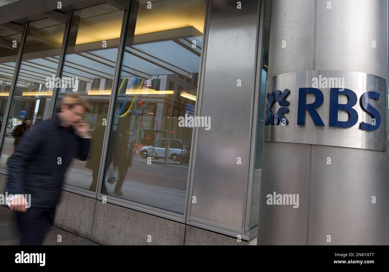 A pedestrian walks past the logo of the Royal Bank Of Scotland (RBS ...