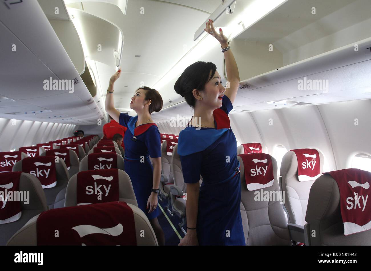 Sky Aviation's flight attendants show to photographers the overhead ...