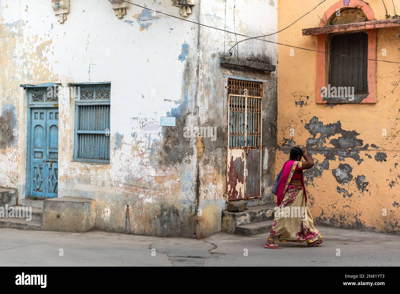 Diu, India - December 2018: A woman walking in the streets past rustic ...