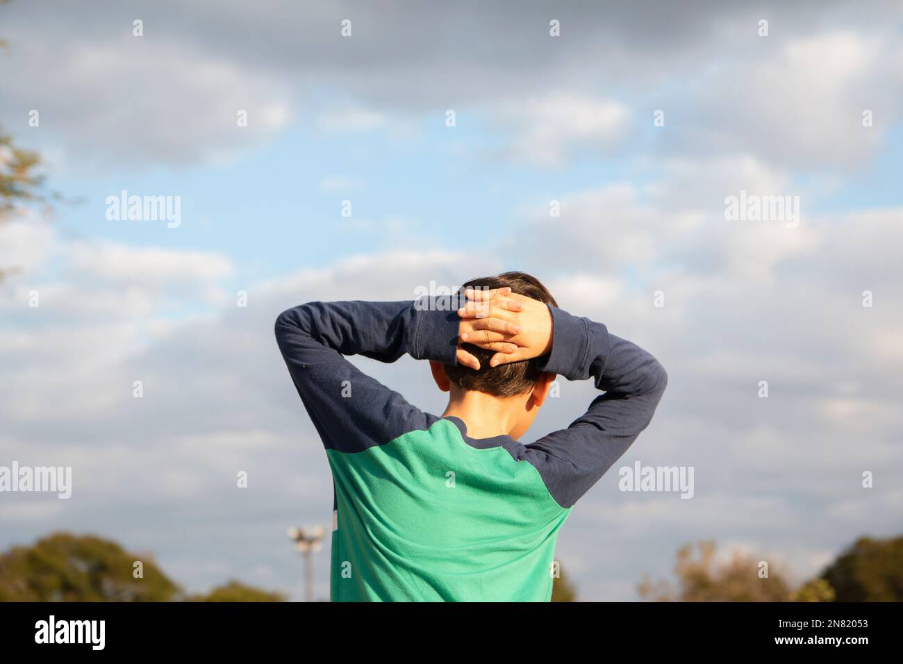 A back view of boy with hands on head looking towards Stock Photo - Alamy