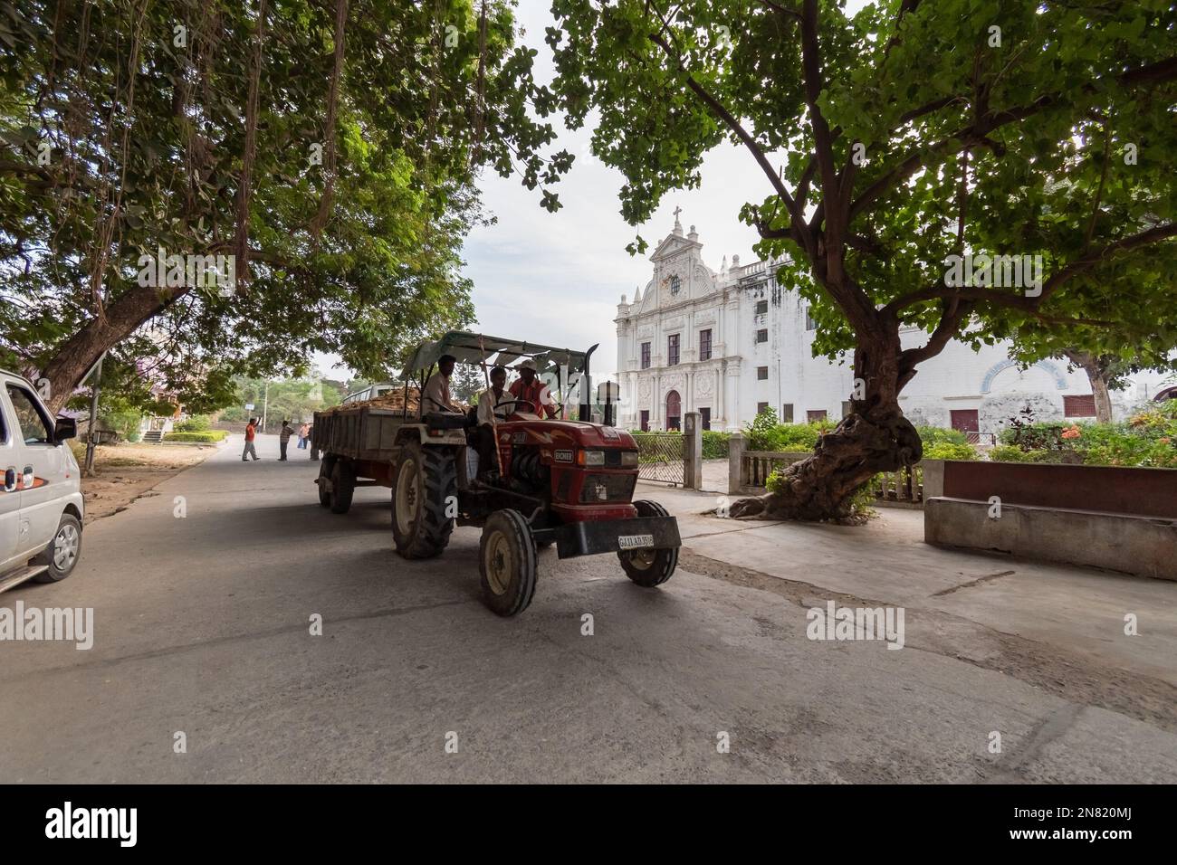 Diu, India - December 2018: People riding a tractor outside the ancient ...