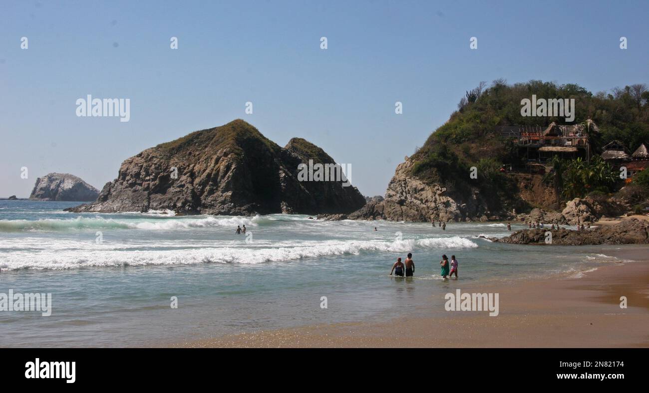 This Dec. 18, 2012 photo shows visitors bathing in the surf along the ...