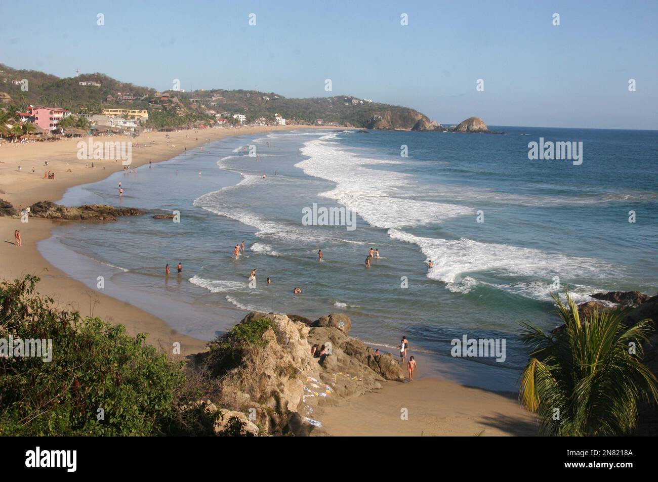 This Jan. 6, 2013 photo shows visitors bathing in the surf along the ...