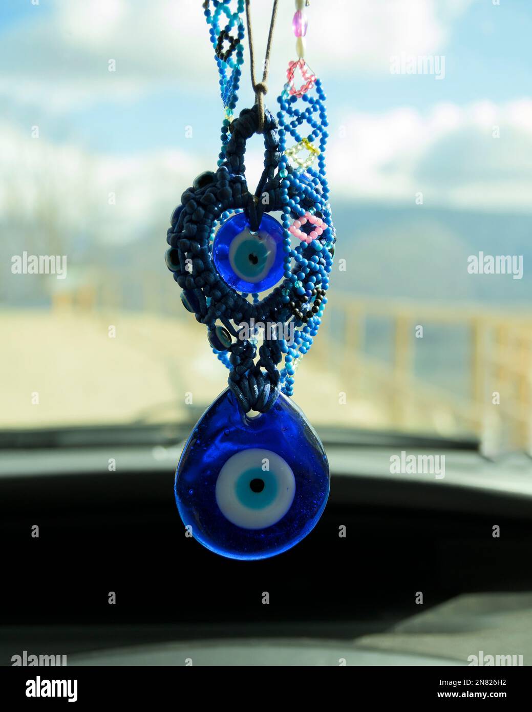 Turkish eye hanging with vertical vibrant colors on car windshield ...