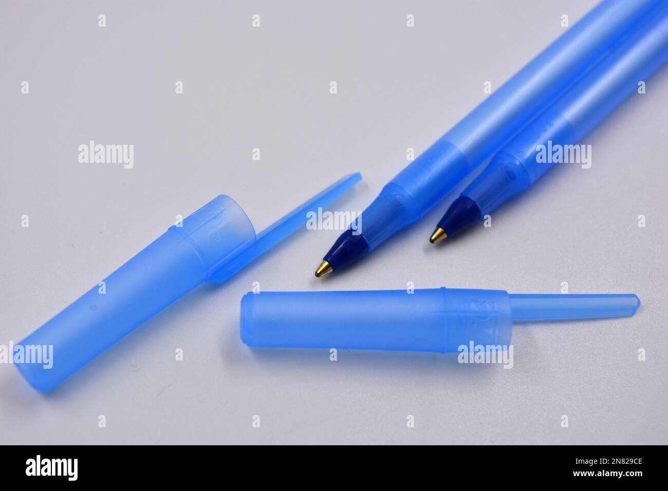 Bright and beautiful two pens with blue ink and two caps made of blue ...