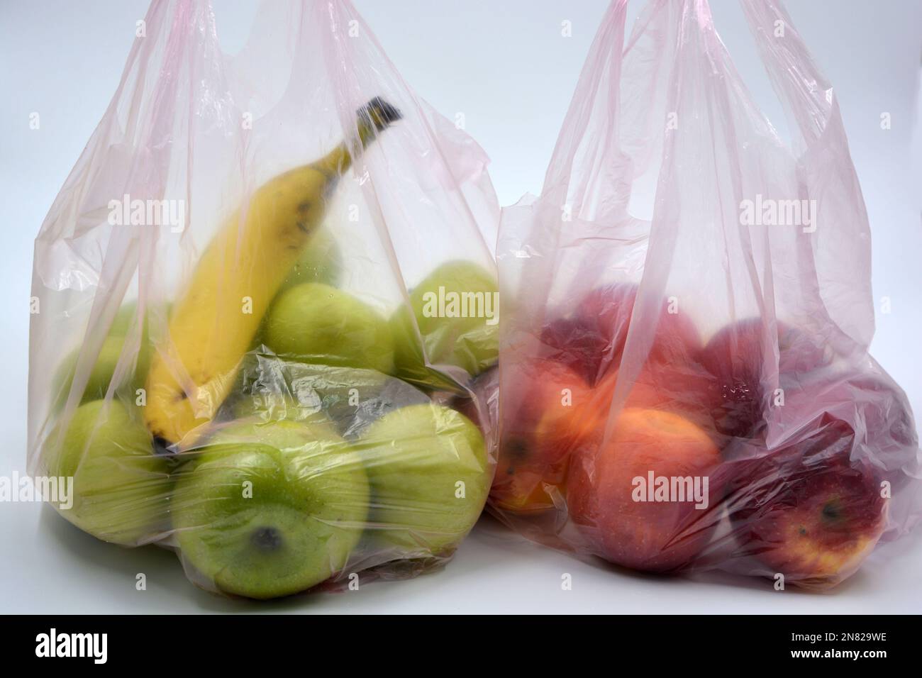 Two large packets of fruit, healthy food, many red, ripe apples and ...