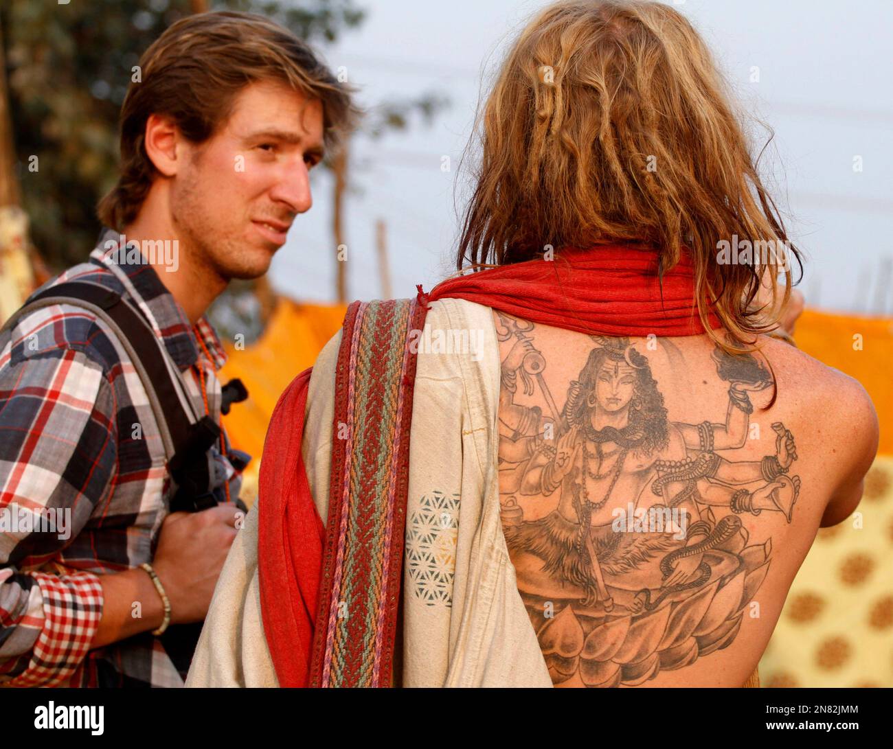 A foreign devotee bearing a tattoo of Hindu Lord Shiva on his back is ...