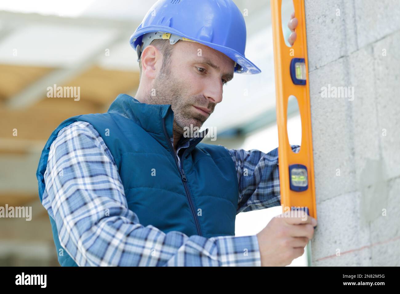 builder holds a professional tool while measuring the wall Stock Photo ...