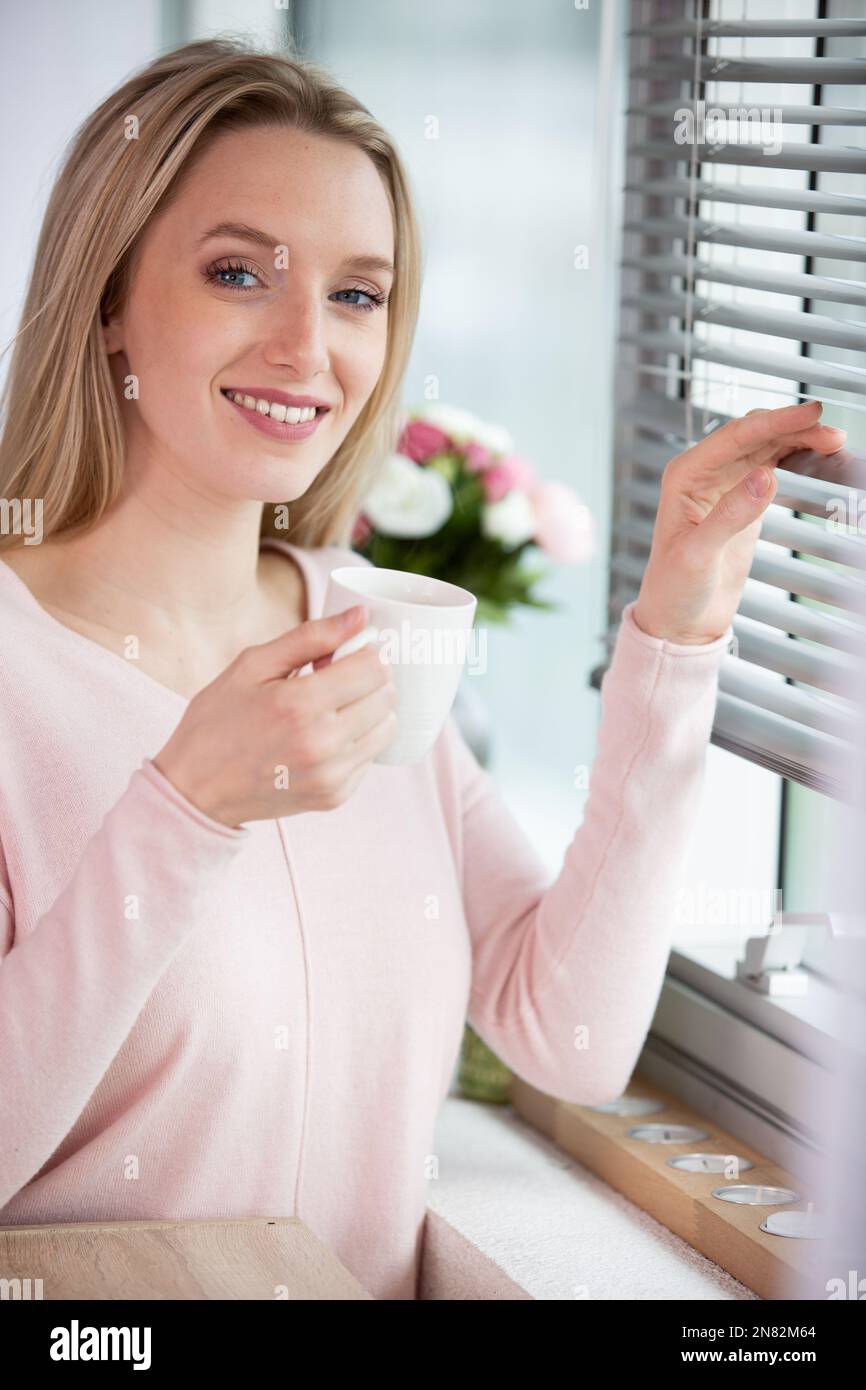 portrait beautiful girl looks through blinds Stock Photo - Alamy