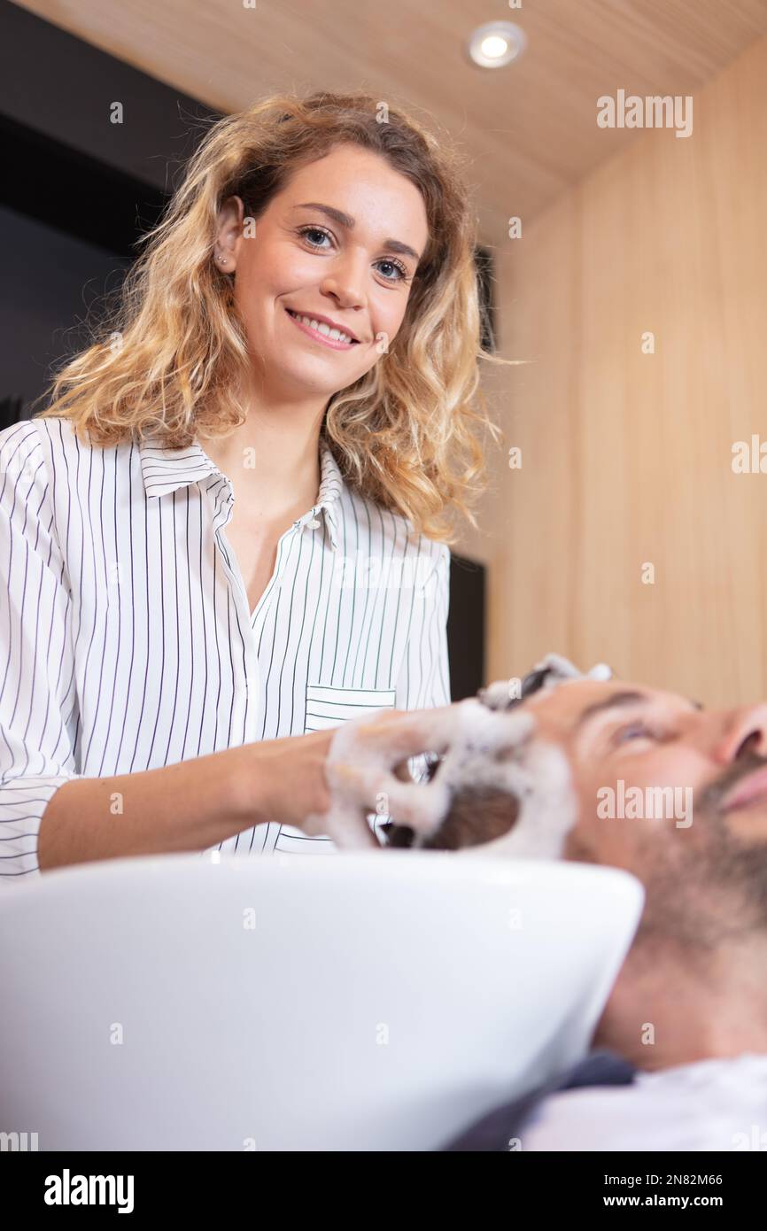 hairstylist smiling at camera while washing clients hair Stock Photo ... hairstylist smiling at camera while washing clients hair Stock Photo ...