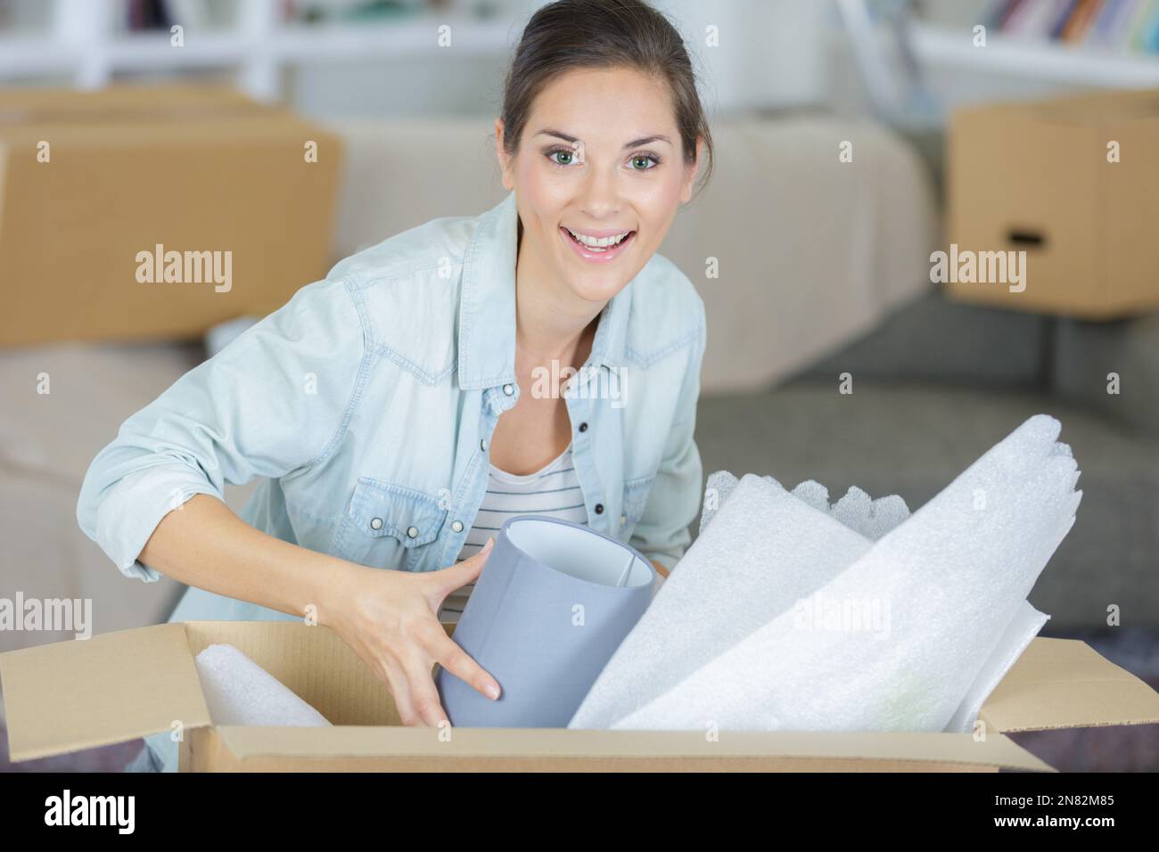 woman taking lamp out of box Stock Photo - Alamy