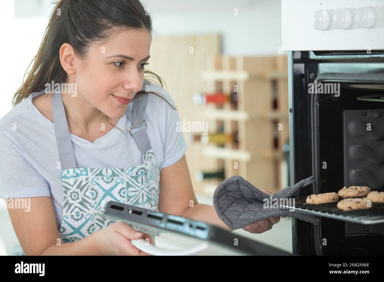 Taking cookies from oven hi-res stock photography and images - Alamy