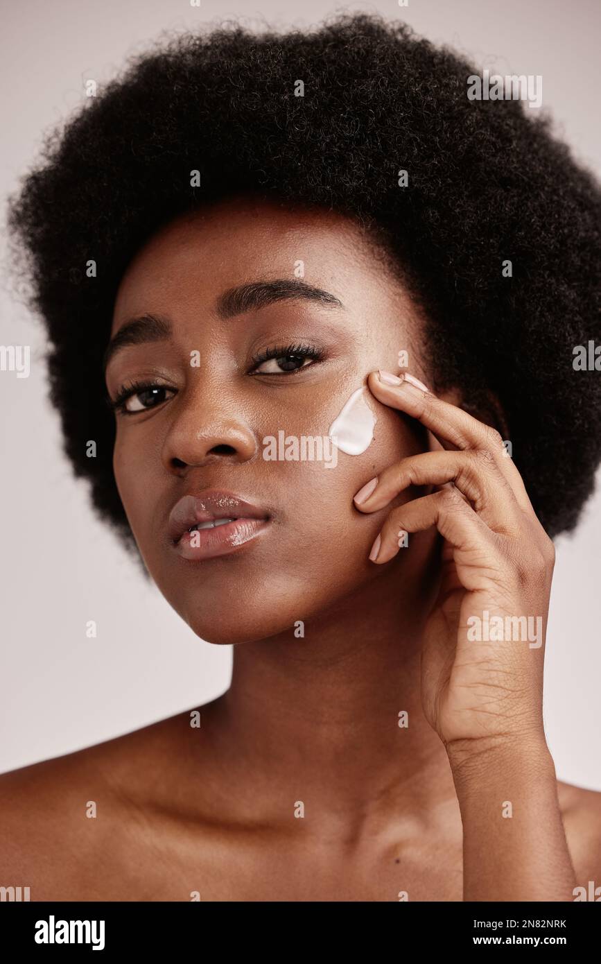 Skincare, face and portrait of black woman with lotion, afro and ...