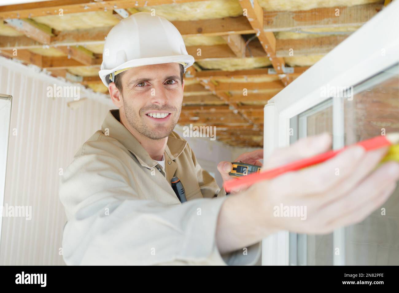 a male builder is measuring window Stock Photo - Alamy