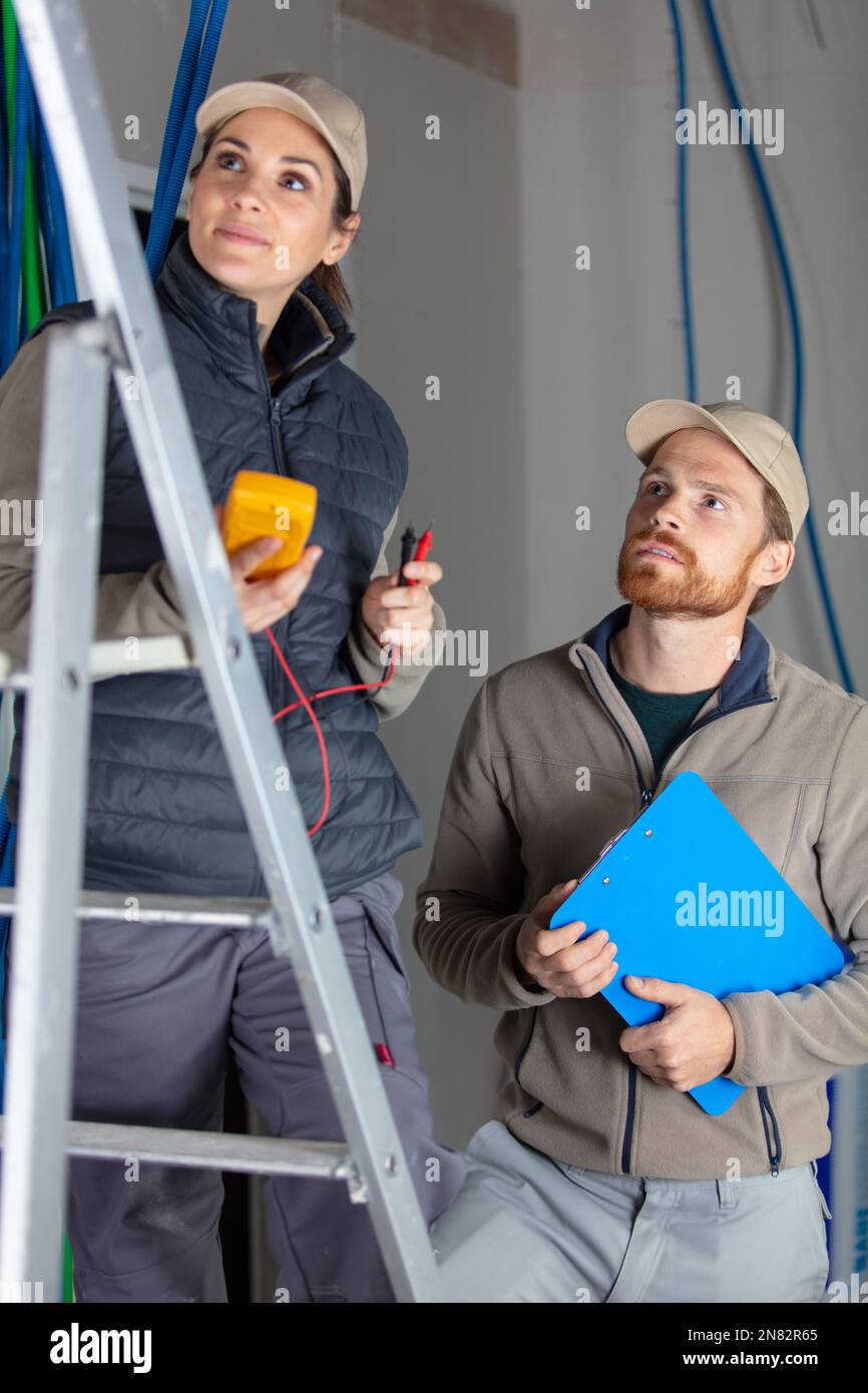 young apprentice electrician with female teacher Stock Photo - Alamy