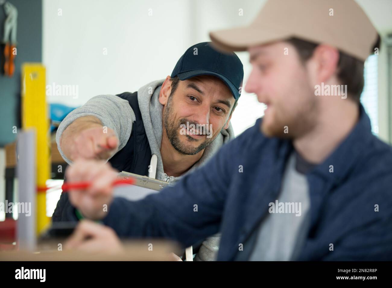 man in factory pointing to attract colleagues attention Stock Photo - Alamy
