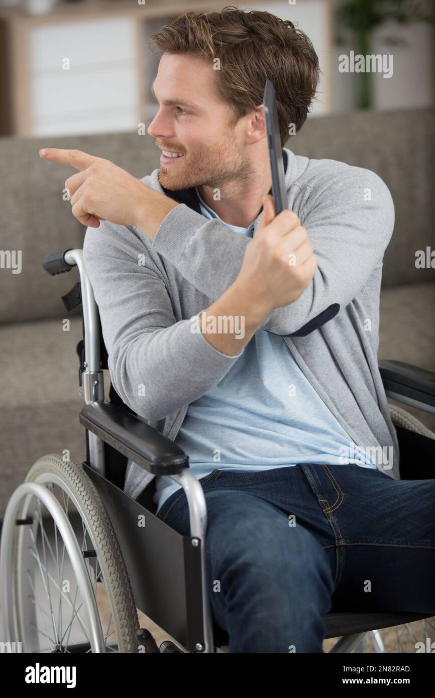 delighted handsome man sitting in the wheelchair Stock Photo - Alamy