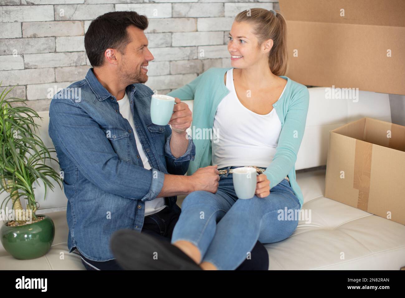 couple having a coffee amidst cardboard boxes Stock Photo - Alamy