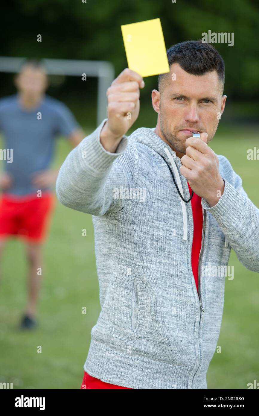 a referee showing yellow card Stock Photo - Alamy