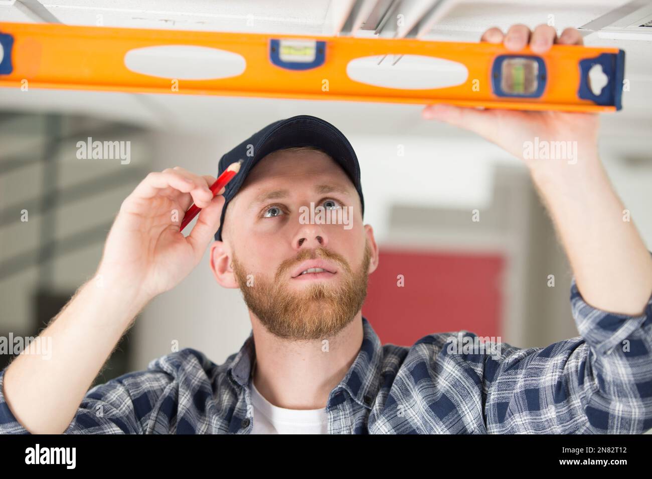 professional construction worker measuring ceiling Stock Photo - Alamy