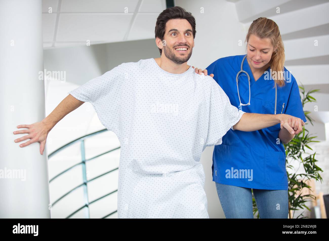 picture of smiling nurse assisting man Stock Photo - Alamy