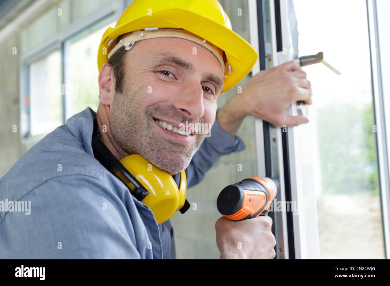 a man drilling window frame Stock Photo - Alamy