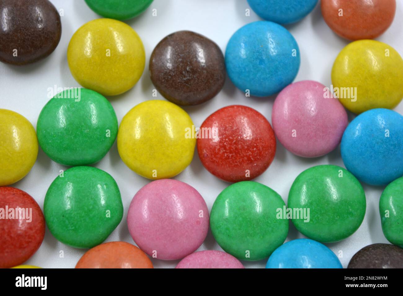 Bright and colorful, multi-colored chocolate candies covered with red ...