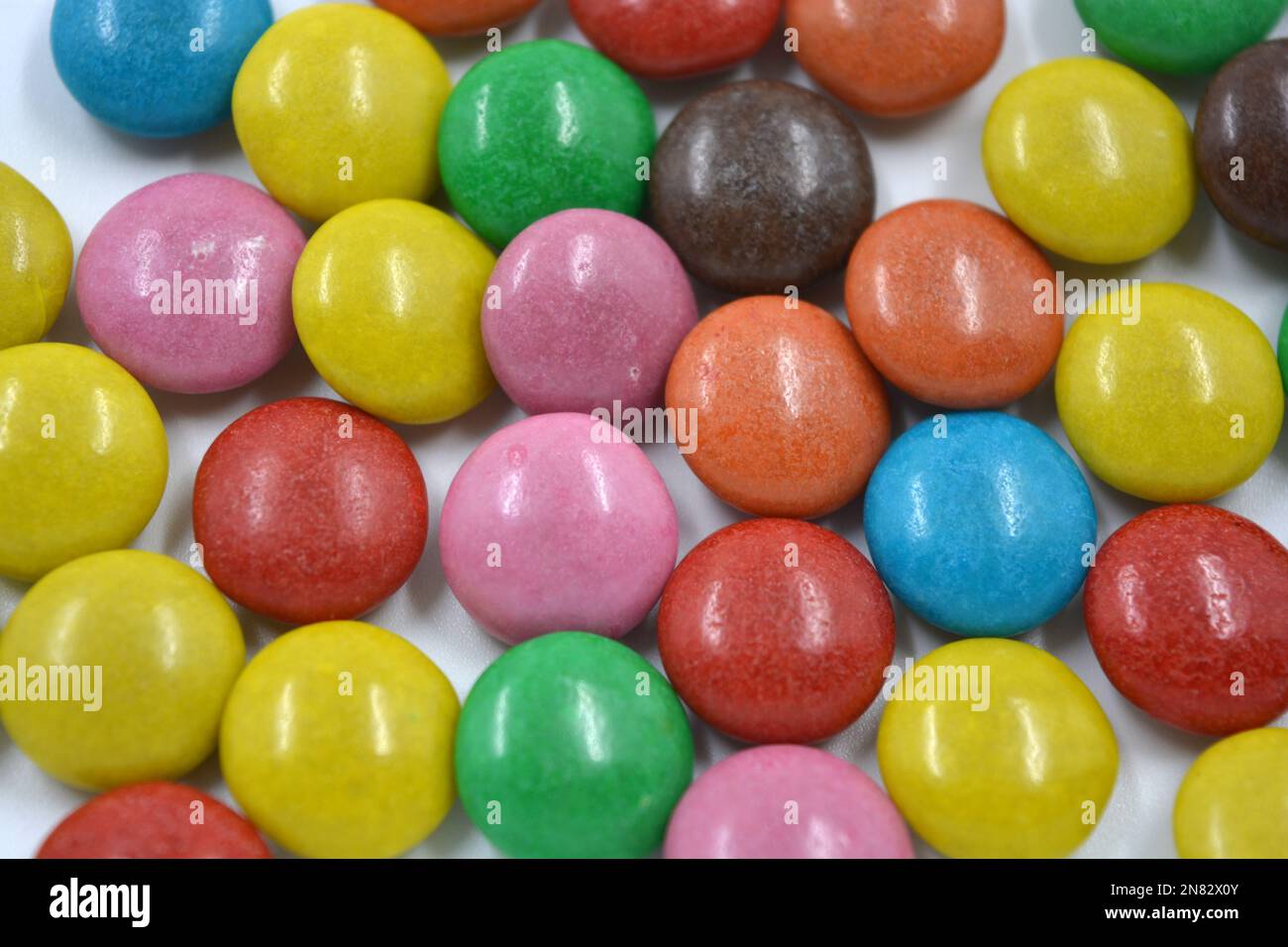 Bright and colorful, multi-colored chocolate candies covered with red ...