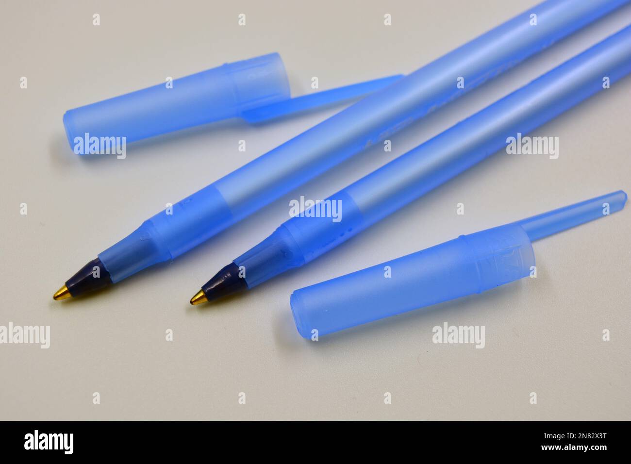 Bright and beautiful two pens with blue ink and two caps made of blue ...