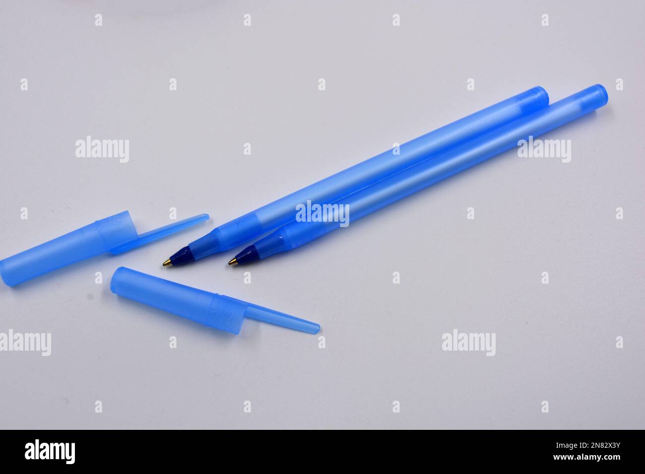 Bright and beautiful two pens with blue ink and two caps made of blue ...