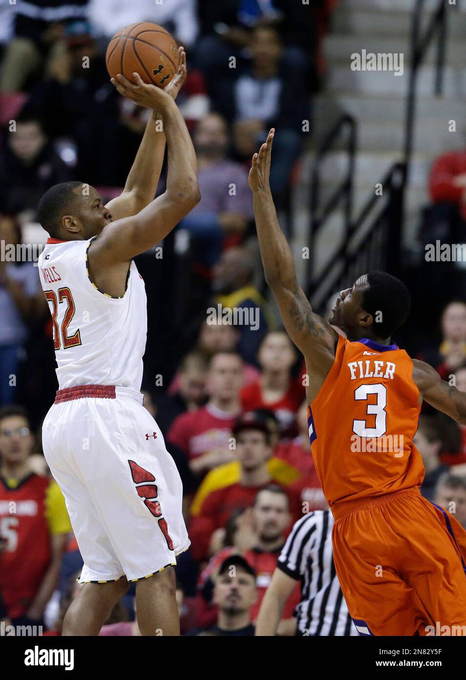 Maryland guard Dez Wells, left, shoots over Clemson guard Adonis Filer ...