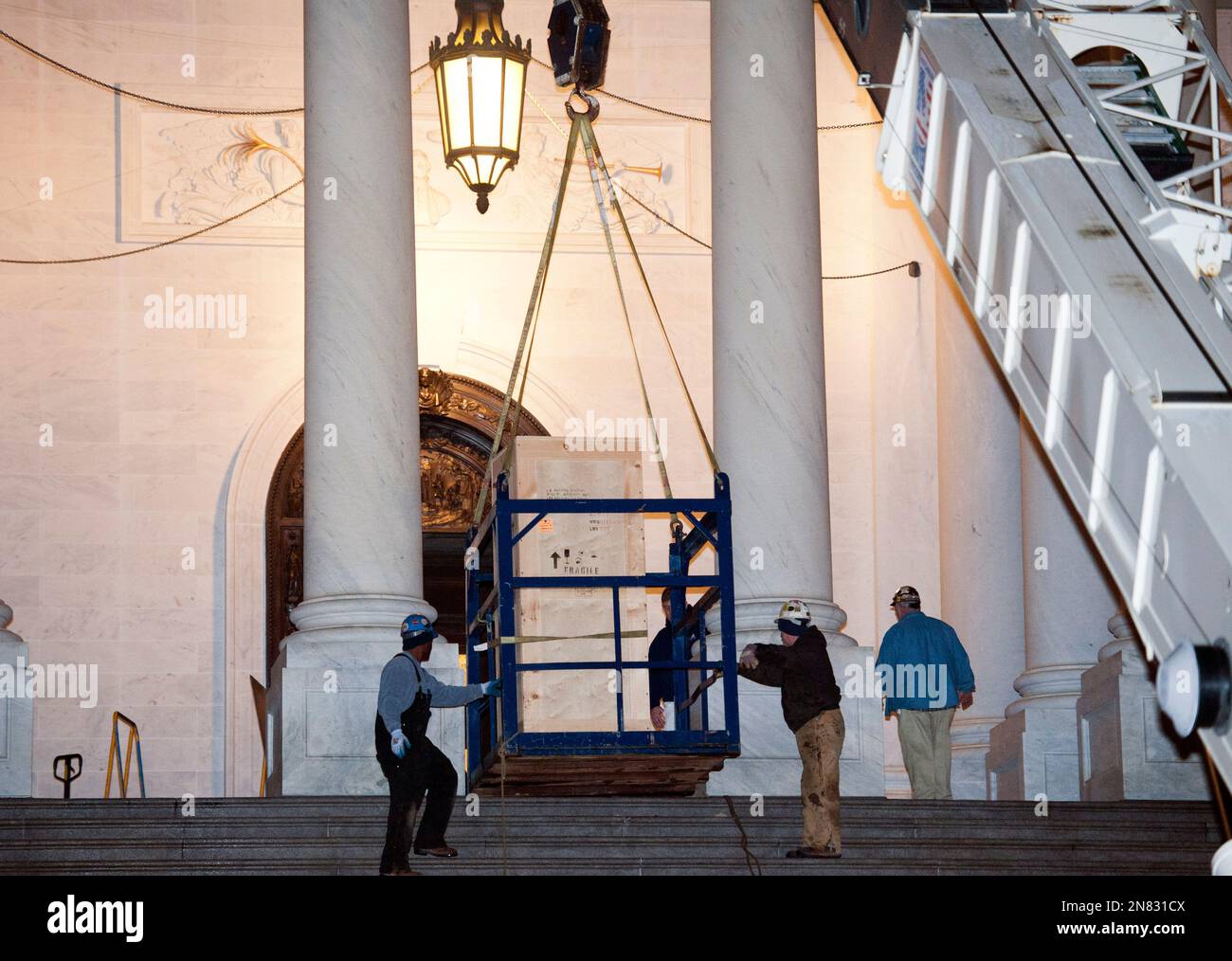 Riggers stabilize the basket on the crate containing the bronze statue ...