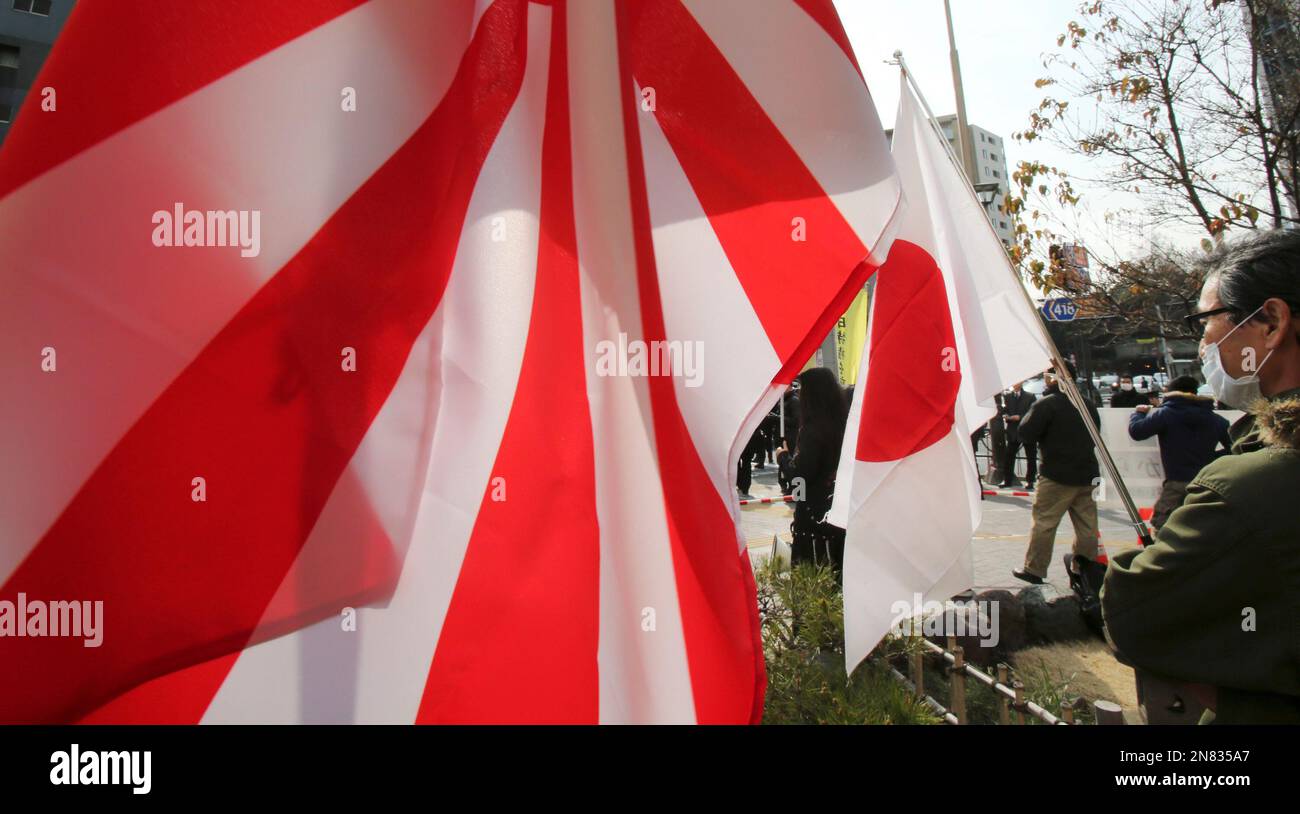 A Japanese protester holds the rising sun flag and Japanese flag during ...